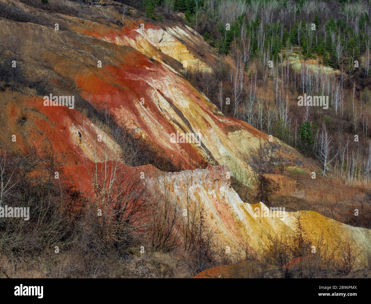 Colorful clay hills at clay quarry. Colorful hills of red yellow and ...