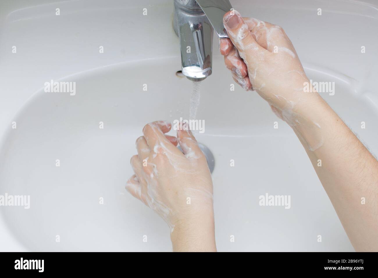 Hygiene concept. Washing hands with soap under the faucet with water ...