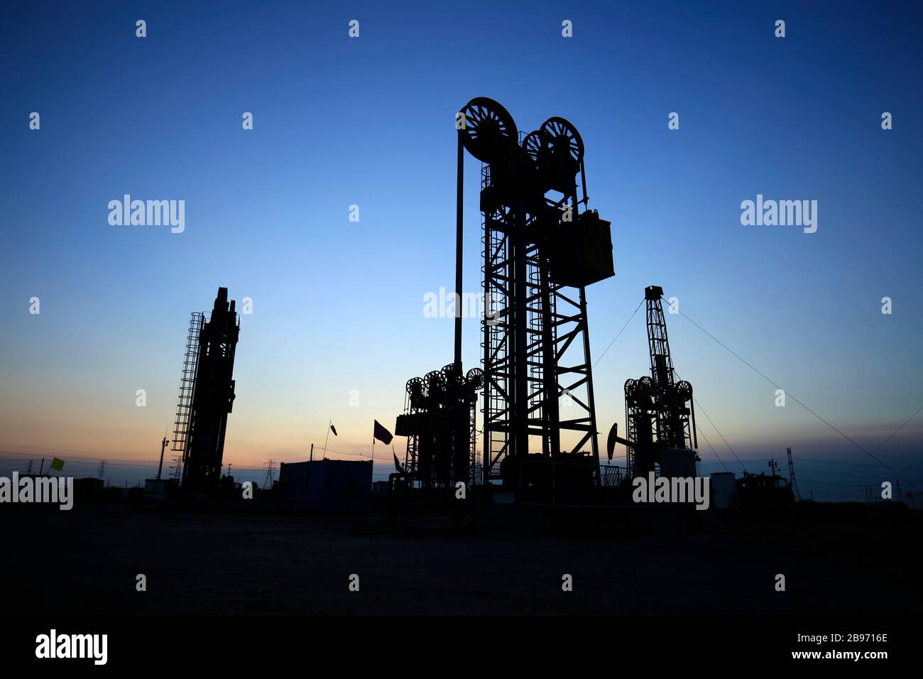 Oil field, oil drilling rig in the evening Stock Photo - Alamy