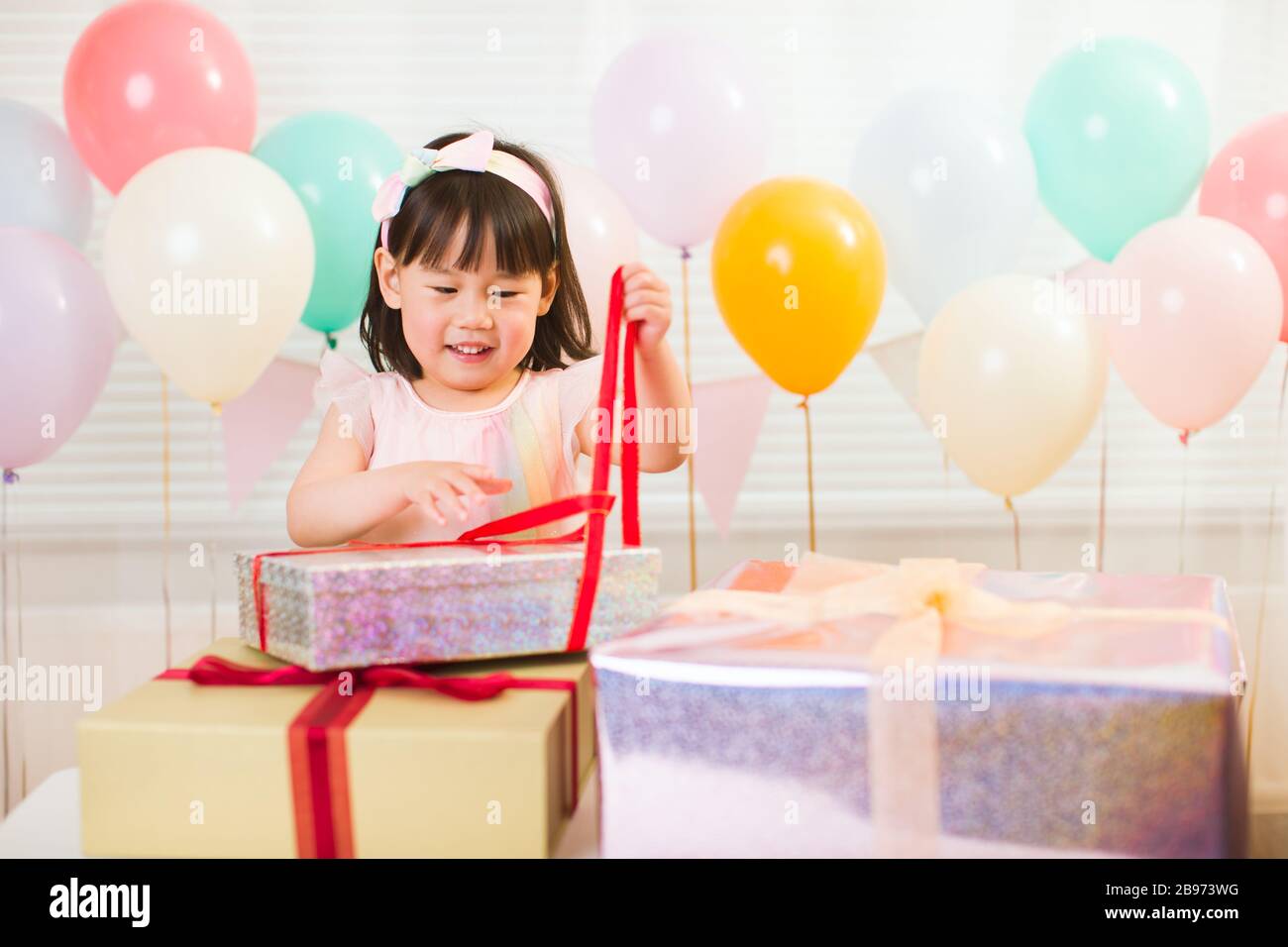 toddler girl unpacking birthday gift box on her birthday party Stock ...