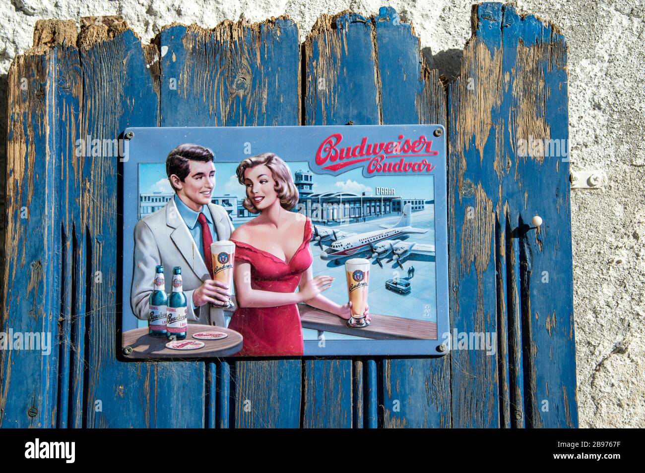 Old advertising sign for Budweiser beer on weathered blue painted ...