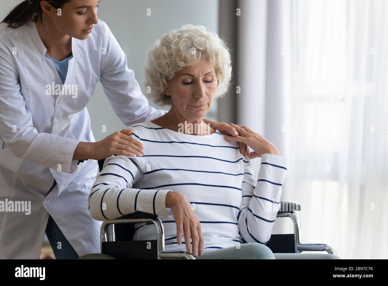 Supportive female nurse take care of disabled elderly woman Stock Photo ...