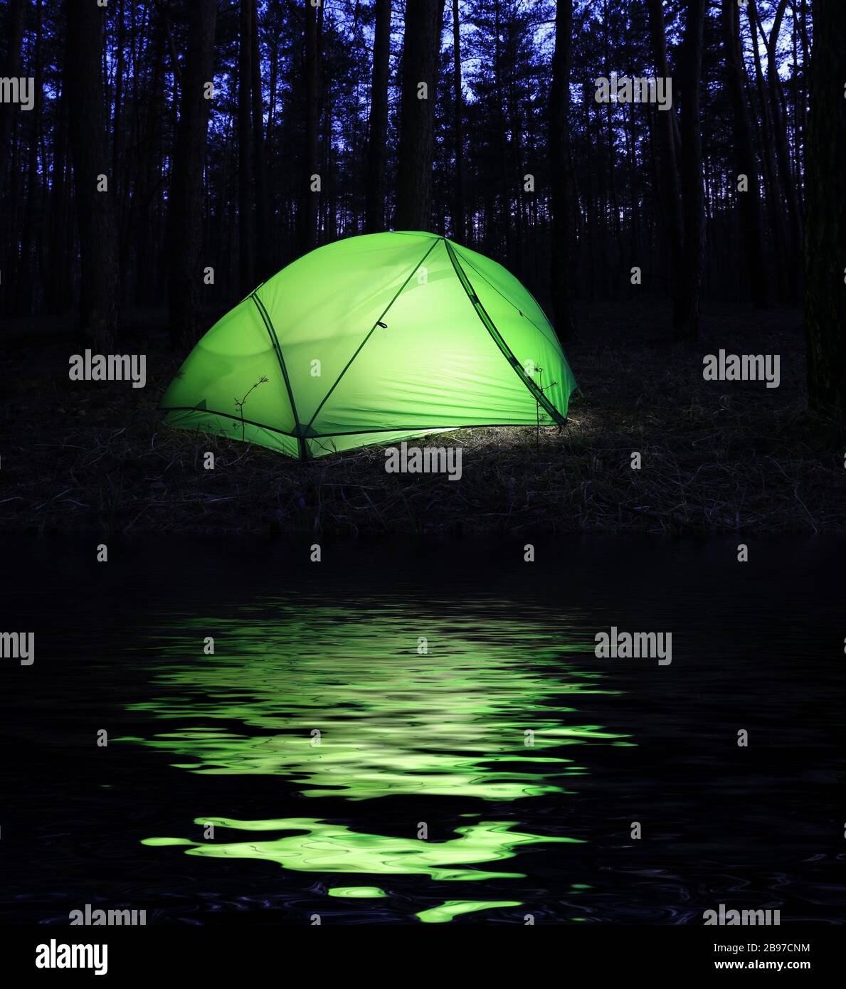 green lighted tourist tent in night forest with water reflection Stock ...