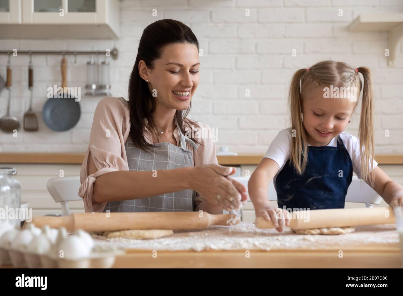 Happy mom and daughter baking pie at home together Stock Photo - Alamy