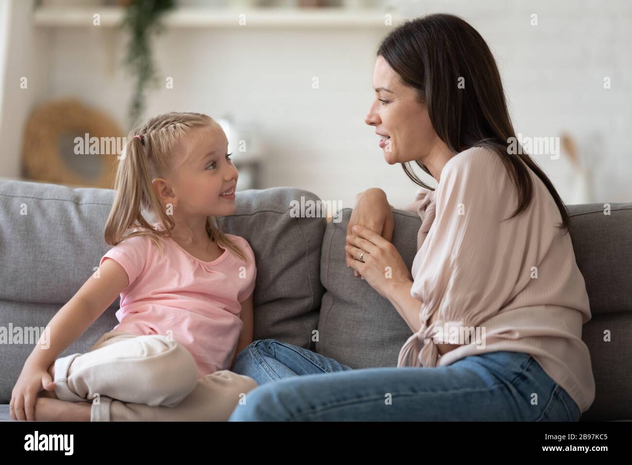 Young mom and little girl have fun talking Stock Photo - Alamy