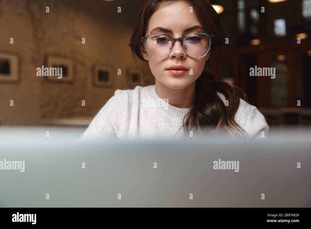 Image of young beautiful caucasian woman wearing eyeglasses using ...