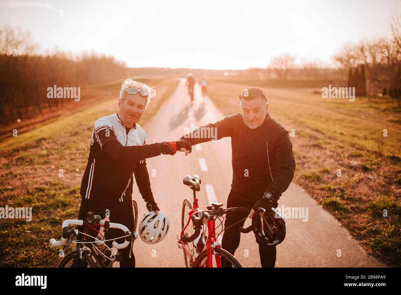 Two cyclists riding a bicycle on the road Stock Photo - Alamy