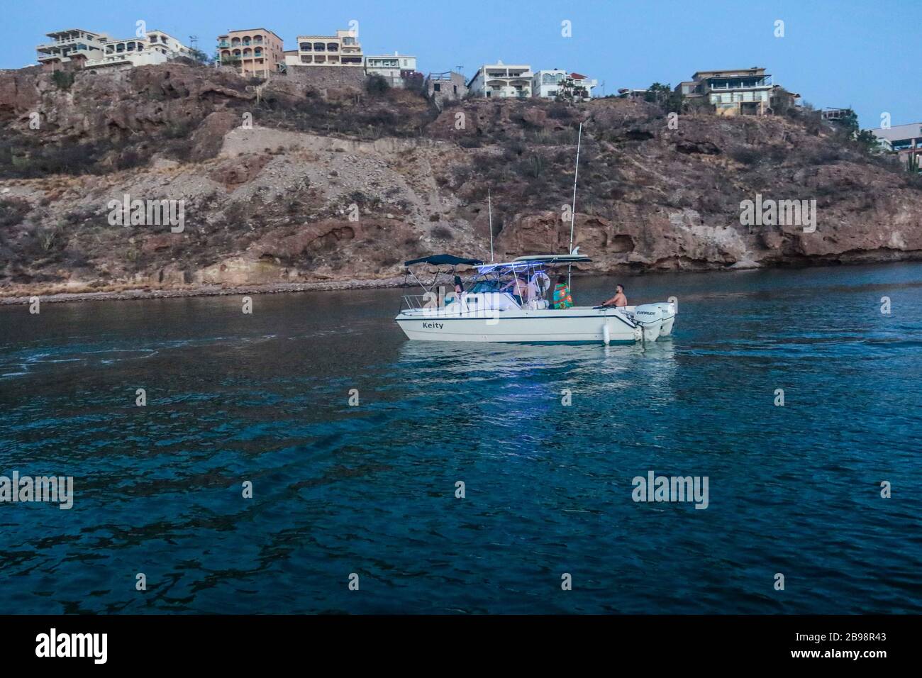 Teenage vacationers enjoy a sunny day, ride a yacht through the bay and ...