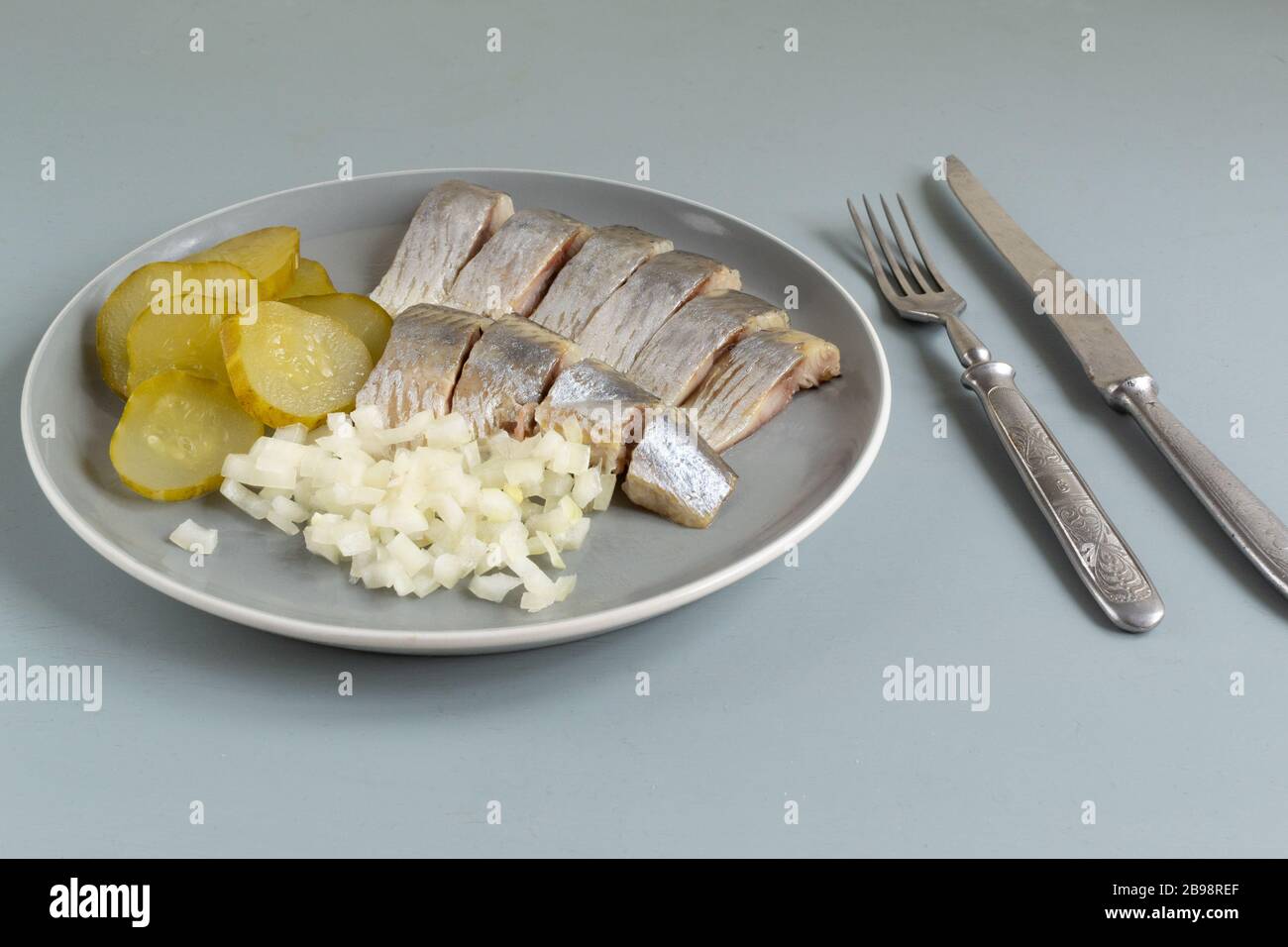 Pickled herring with pickles and onion rings. Traditional dutch food. Healthy food. Minimalism ...