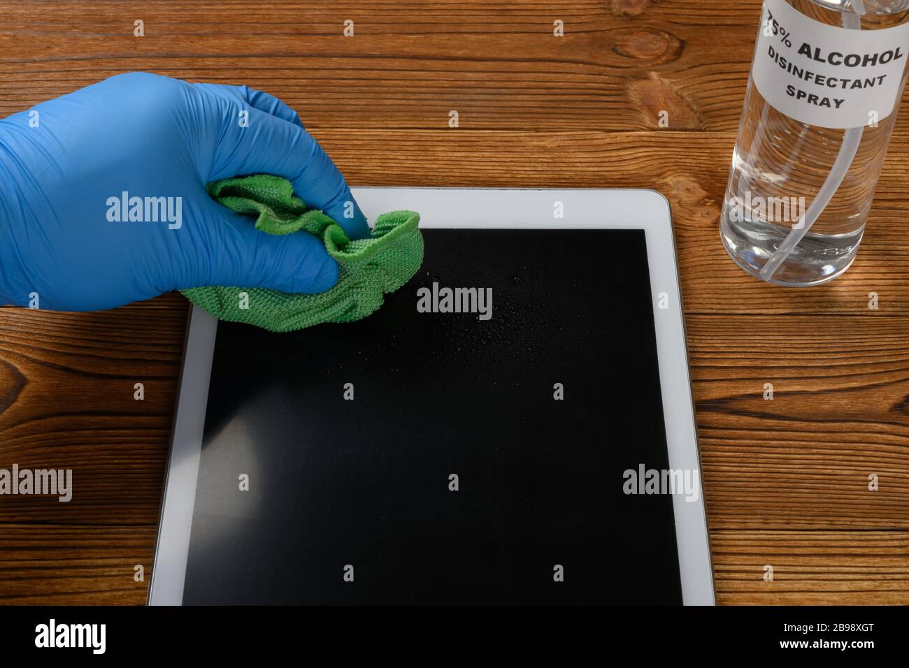 wiping a tablet with 75 percent alcohol disinfectant liquid Stock Photo ...