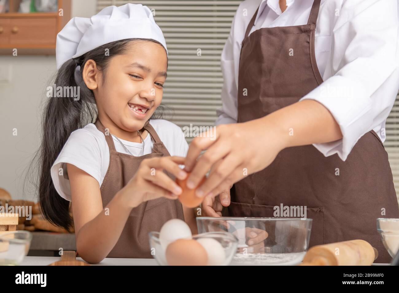 Child helping parent cook hi-res stock photography and images - Alamy