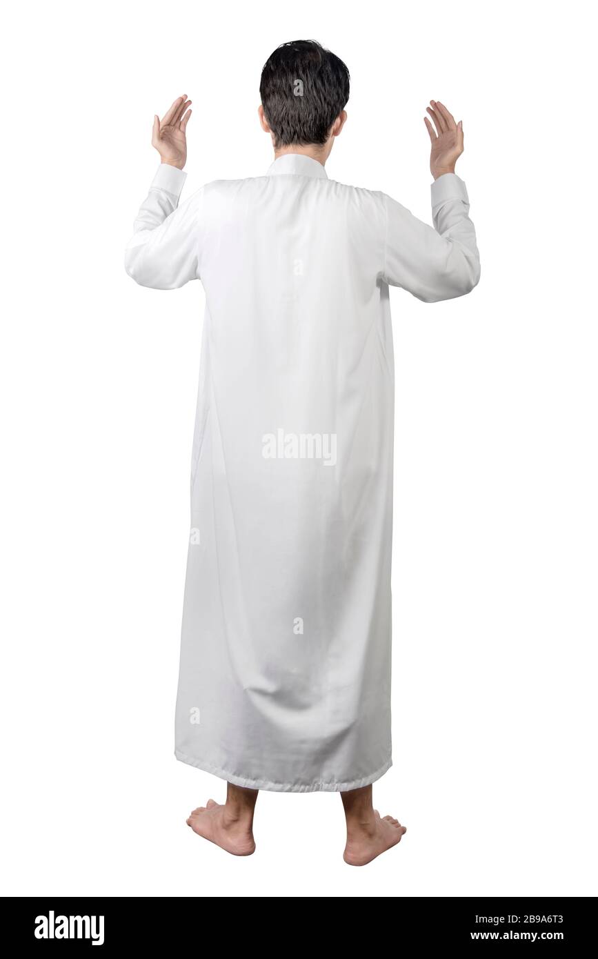 Rear view of Asian Muslim man standing while raised hands and praying ...