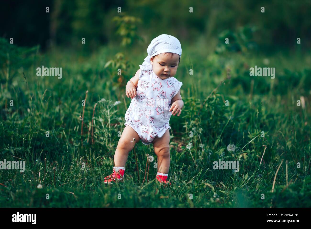A little girl blowing soap bubbles, spring portrait beautiful one year ...