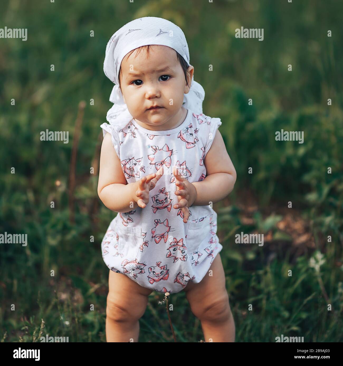 A little girl blowing soap bubbles, spring portrait beautiful one year ...