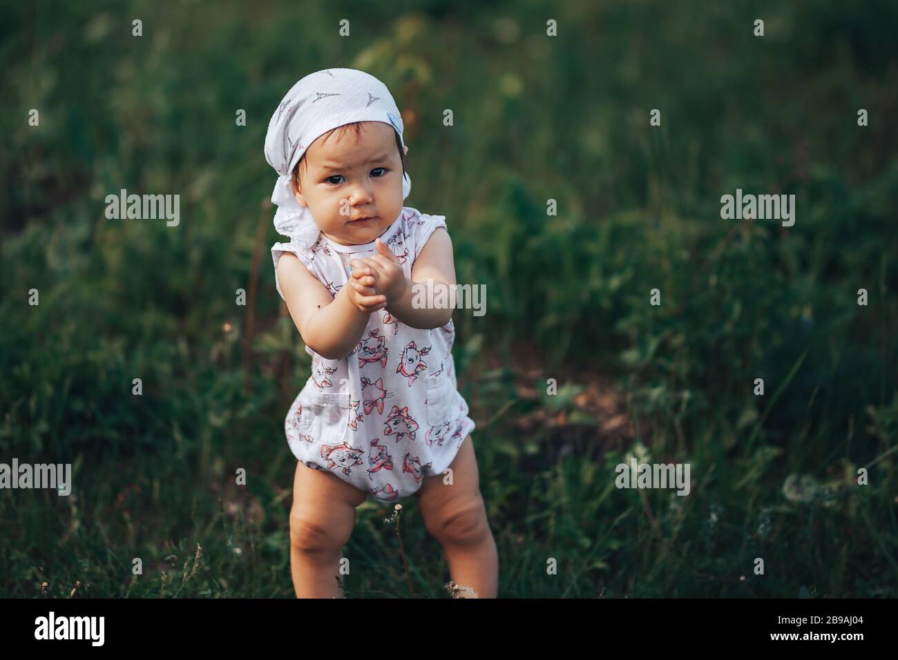 A little girl blowing soap bubbles, spring portrait beautiful one year ...