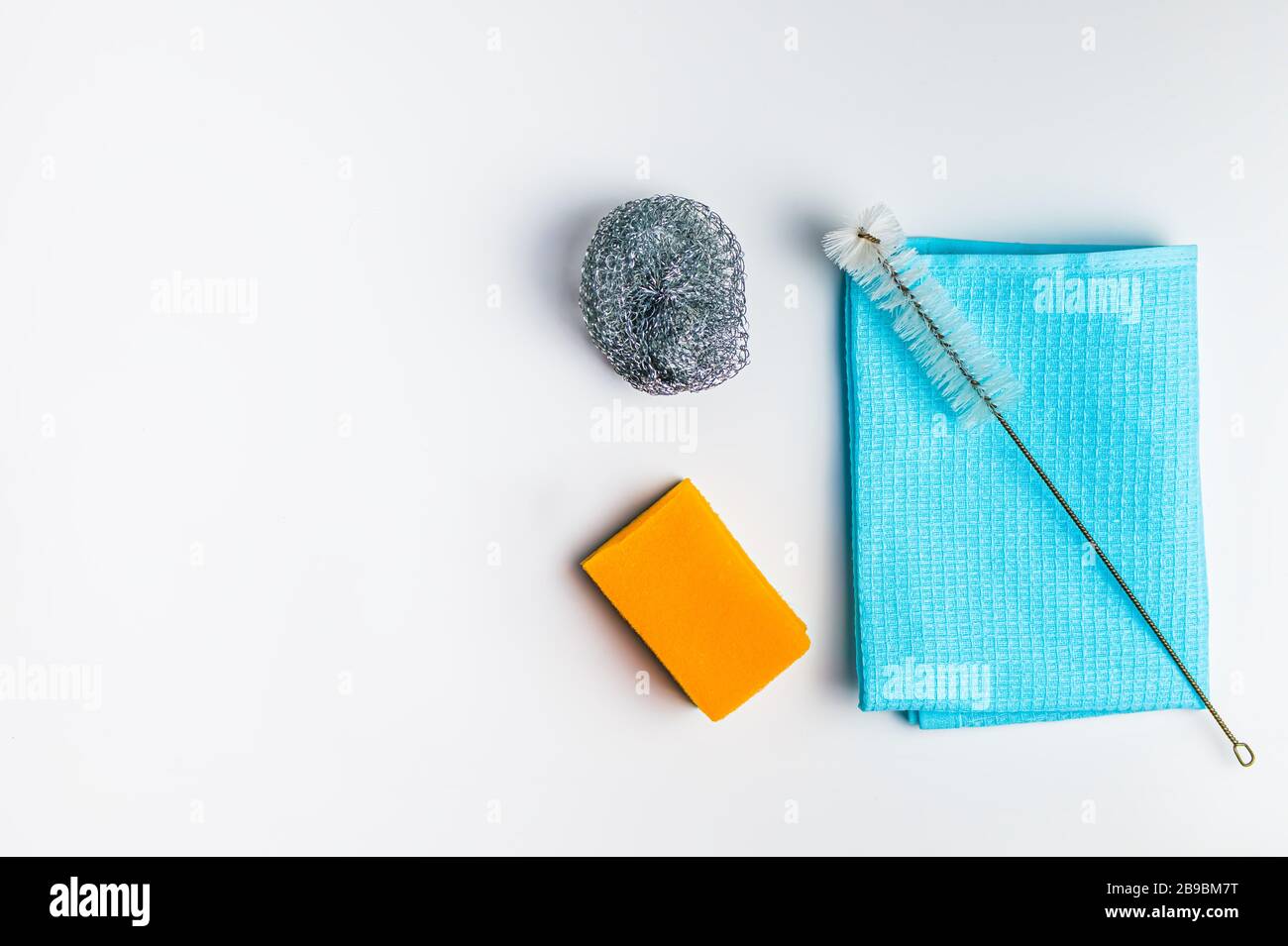 cleanliness and cleaning. blue rag, orange sponge and brush on white ...