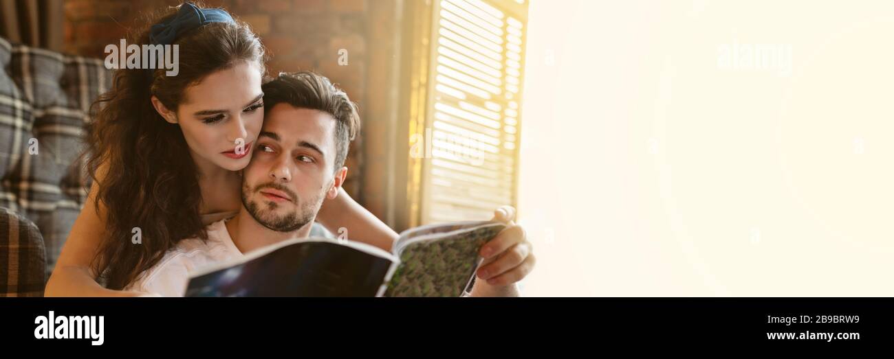Portrait of a charming young couple at home. Woman is embracing her ...