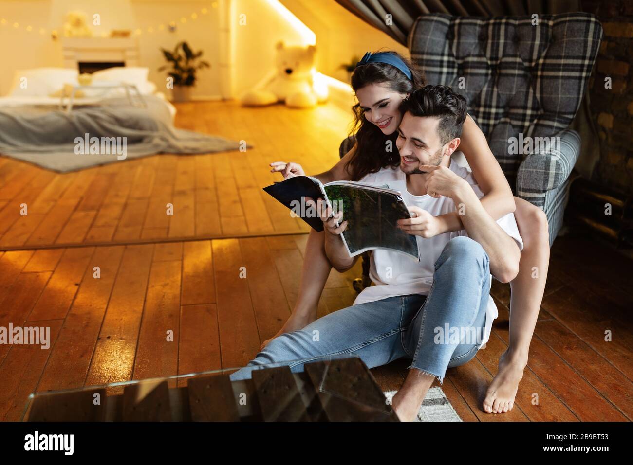 Portrait of a charming young couple at home. Woman is embracing her ...