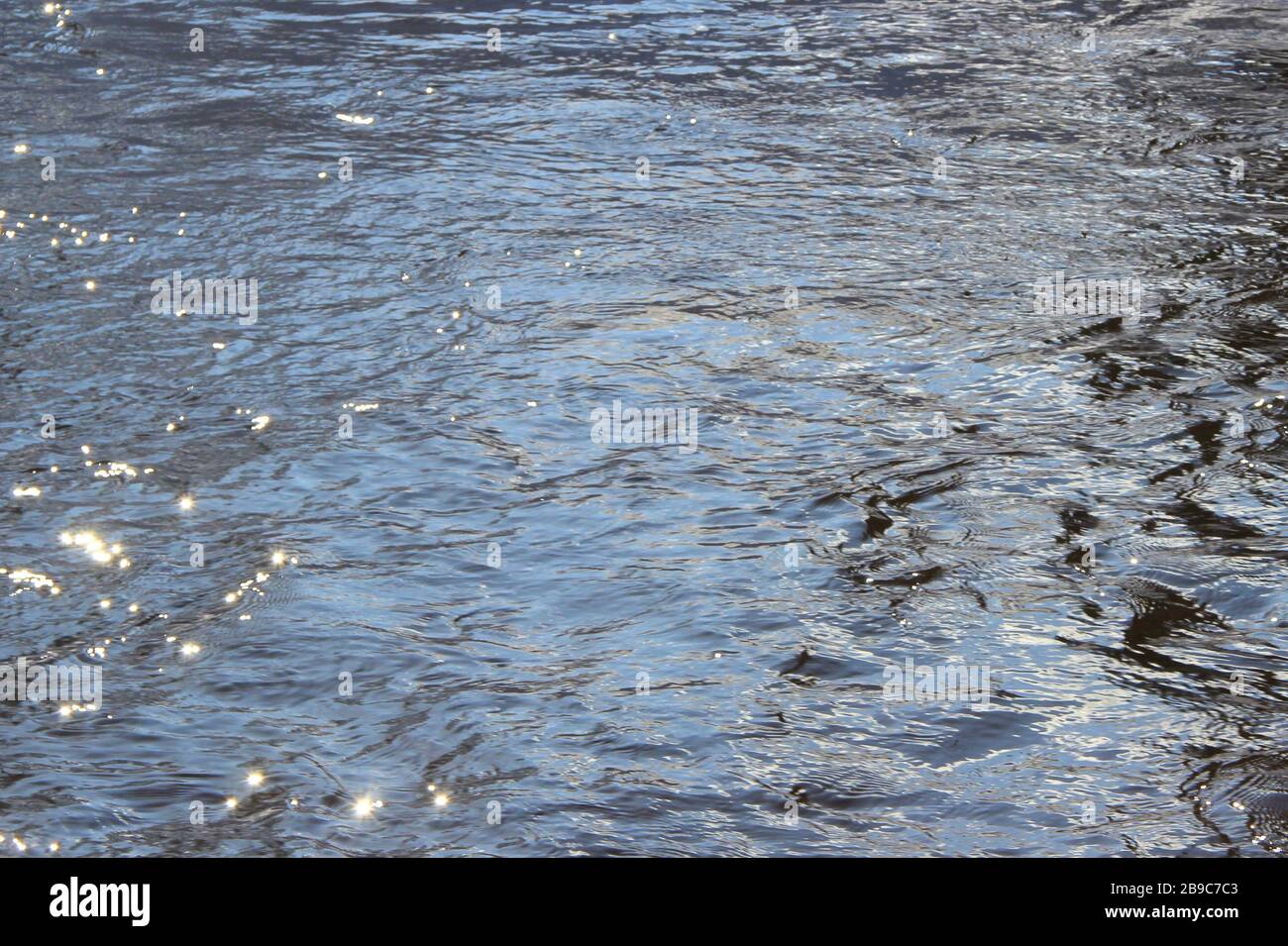 Water surface with waves and glare of light. Place for text and design ...