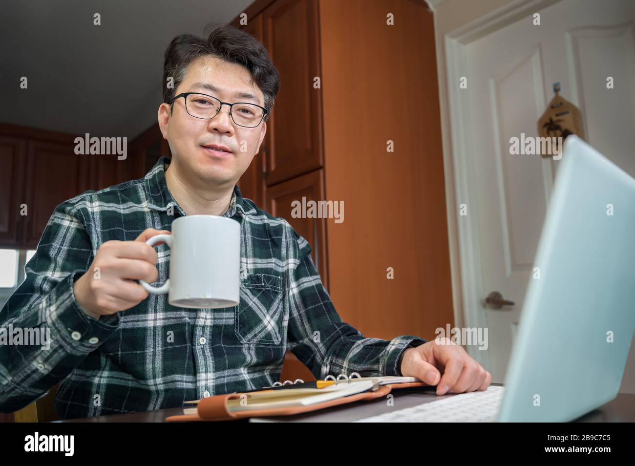 An Asian man who is self-isolated and working from home because of a ...