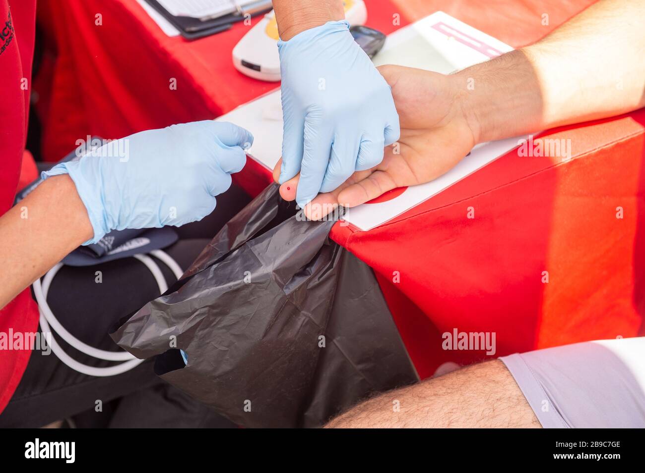 Nurse wearing gloves with a patient doing a pin prick test on the ...
