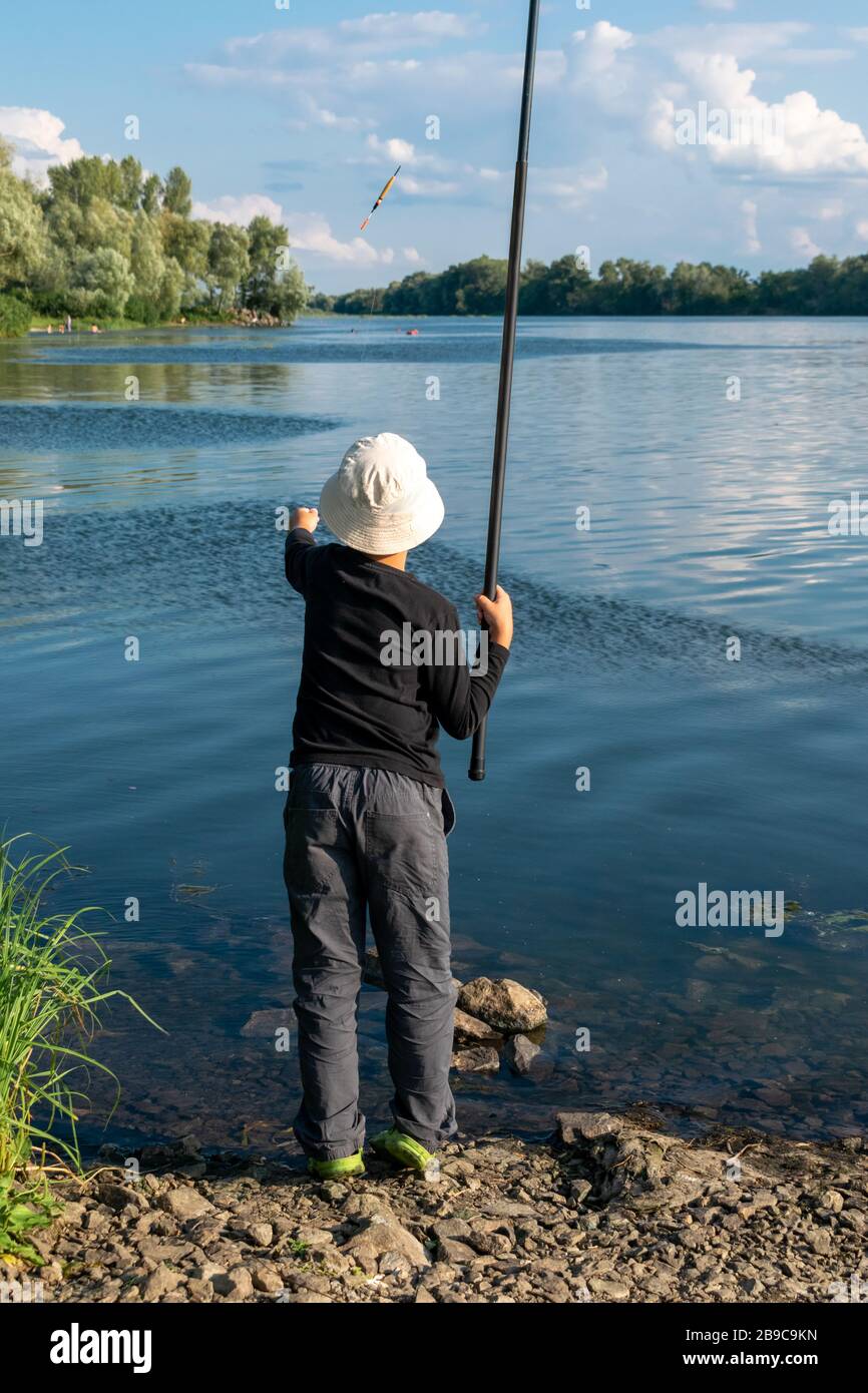 Boy catching fish on the river on a sunny day Stock Photo - Alamy