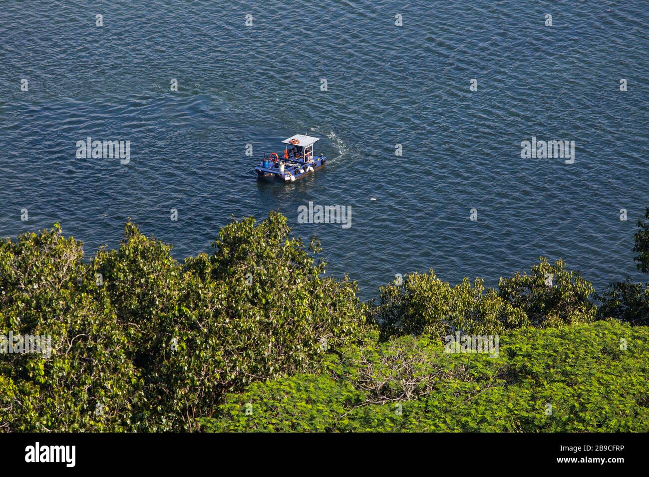 Aerial view of a small operational boat cleaning up the water ...