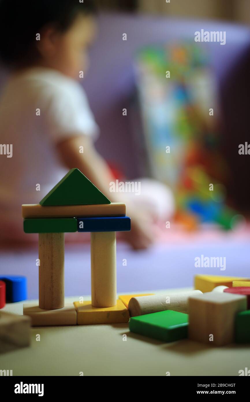 blurred baby playing toy block in the background. selective focus on ...