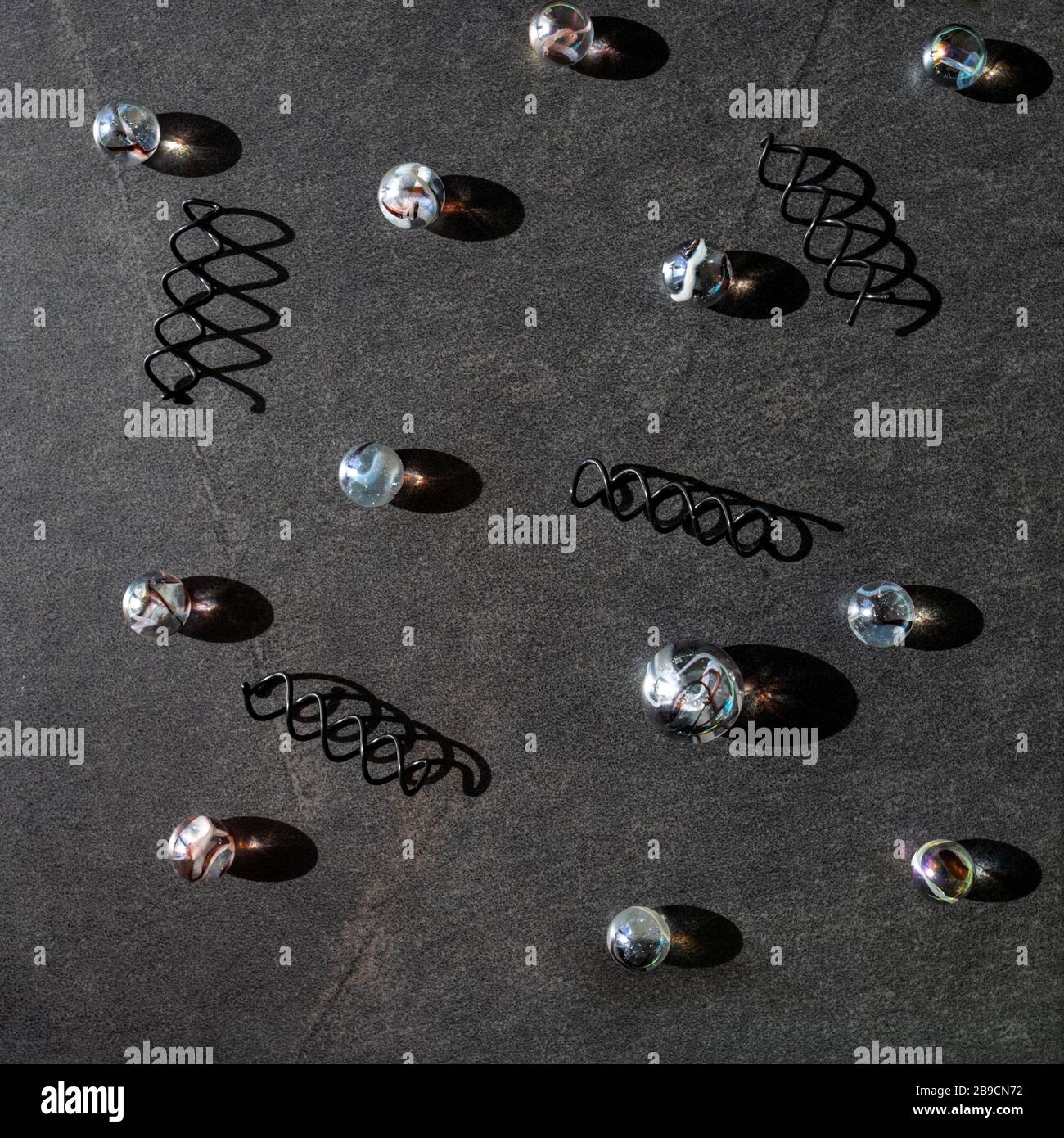 abstract black coil springs parts and few glass balls on dark ...