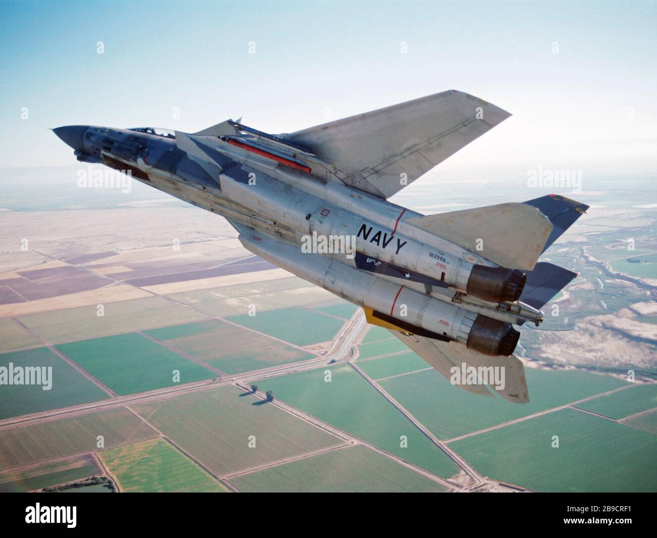 Camouflaged U.S. Navy F-14 Tomcat climbs after takeoff over California ...