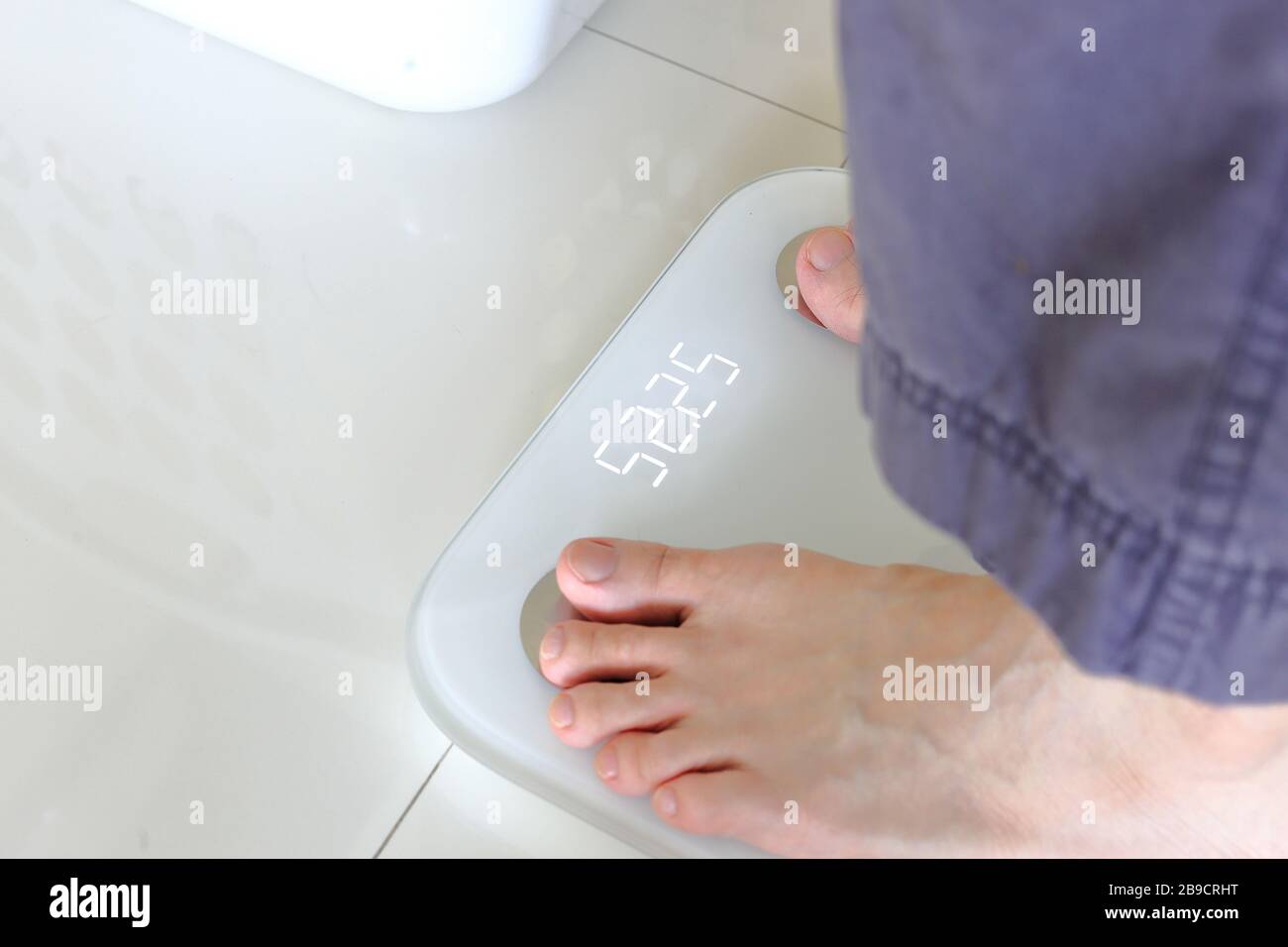 Bare feet standing on a scales. Lose weight concept with person on a ...