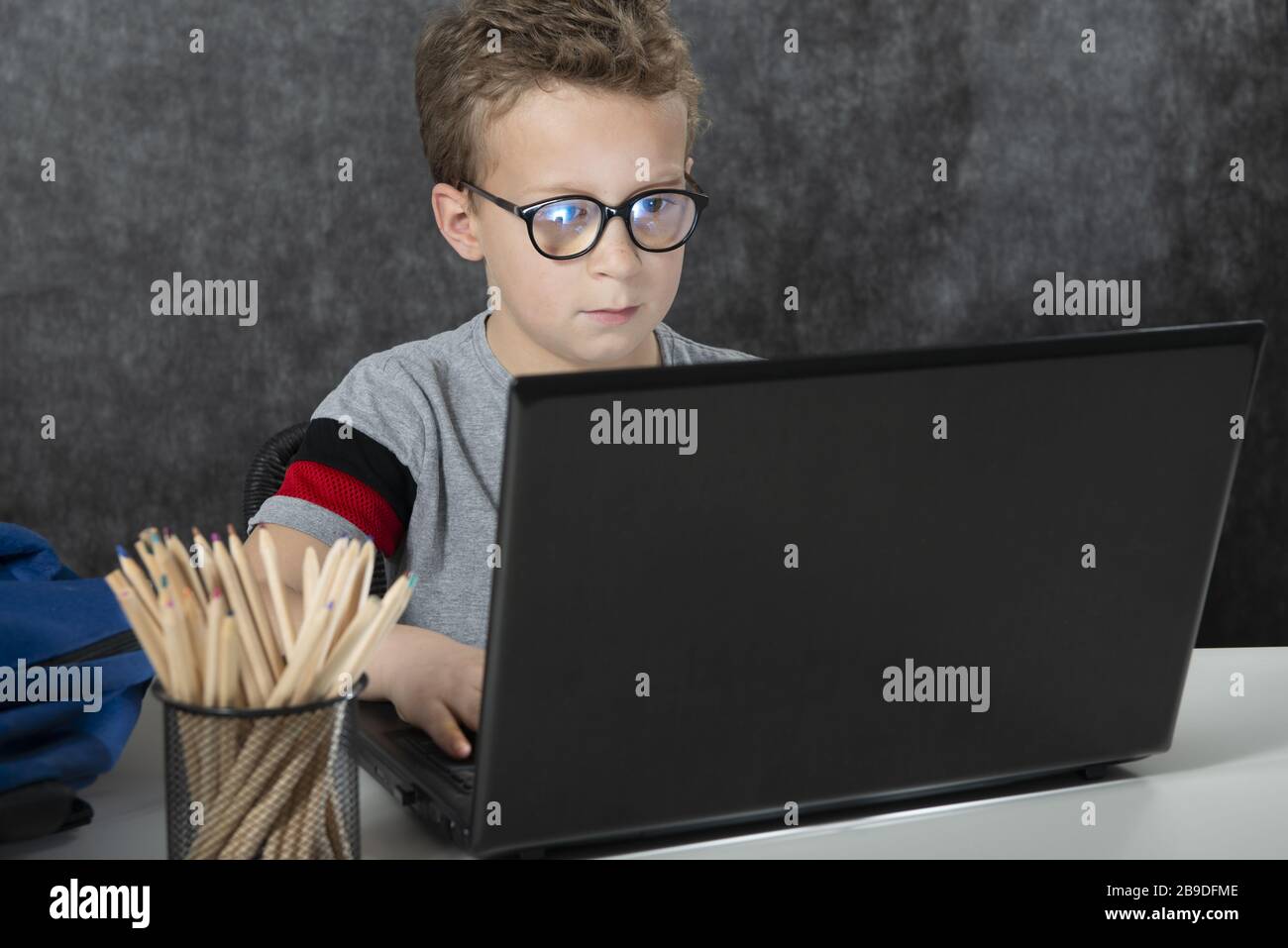 serious boy sitting with a laptop computer Stock Photo - Alamy