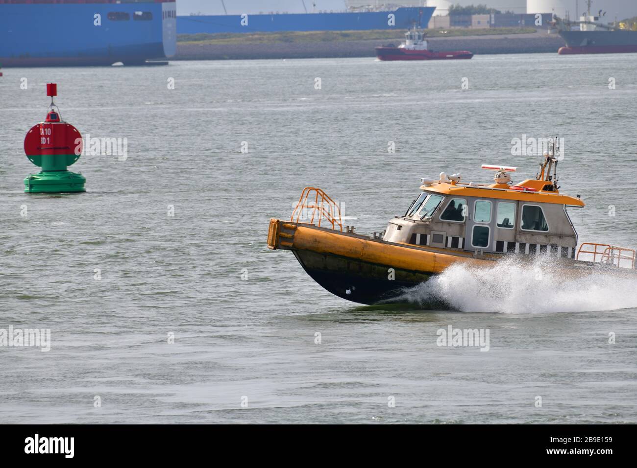 Fast approaching bright orange pilot boat at the entrance of the Nieuwe ...