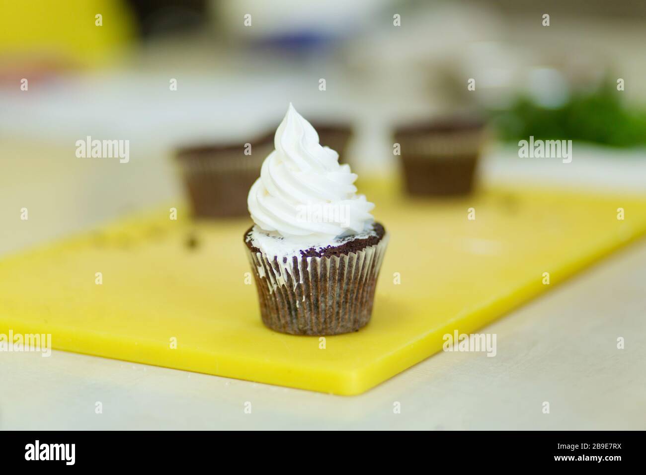 The process of decorating chocolate cupcakes with airy protein cream ...