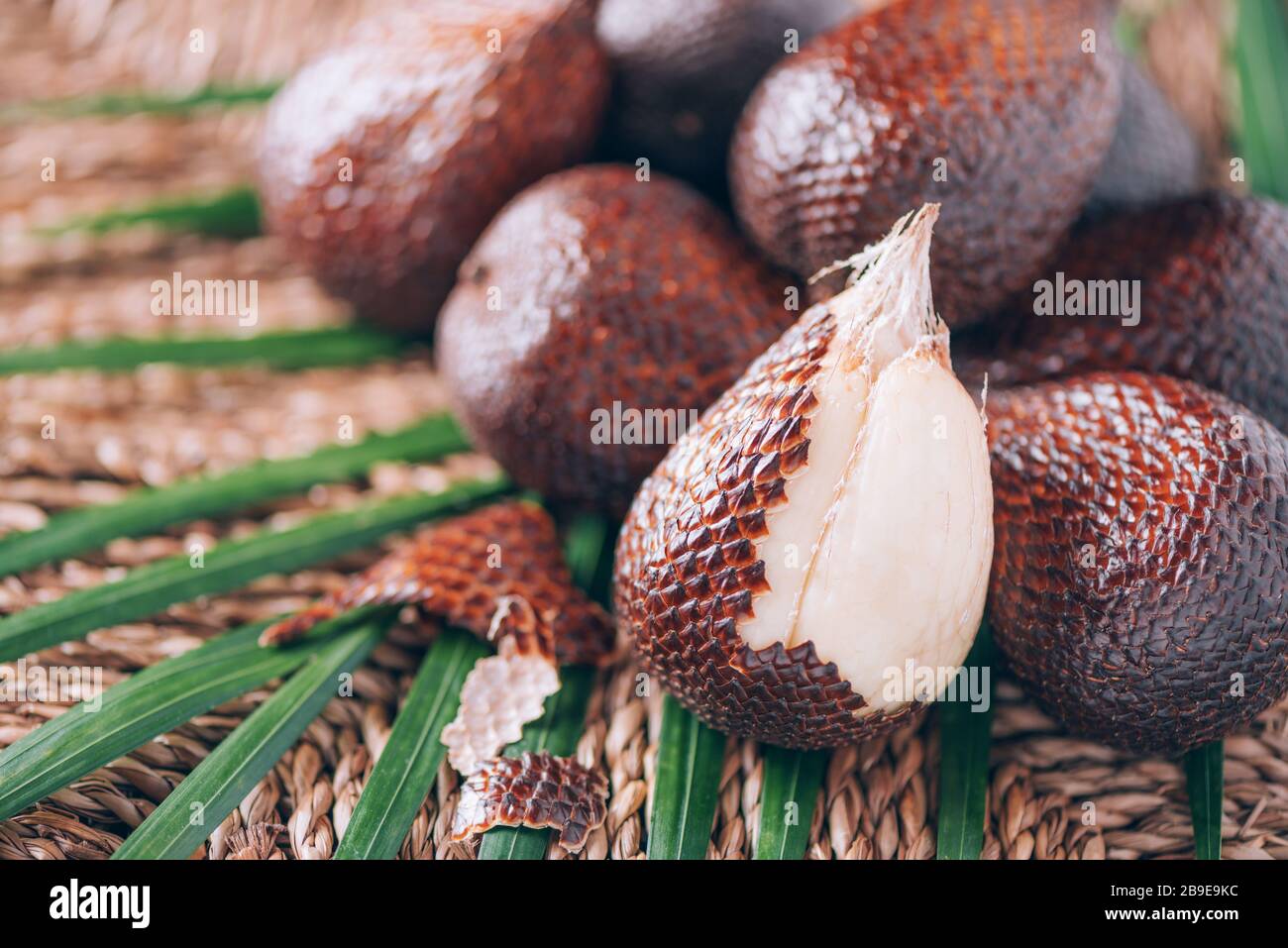 Red Salacca. Salak, snake fruits with palm leaves on rattan background ...