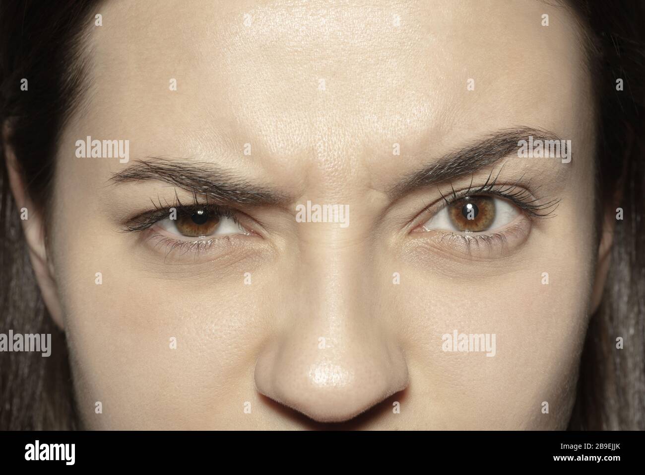 Angry. Close up of face of beautiful caucasian young woman, focus on ...