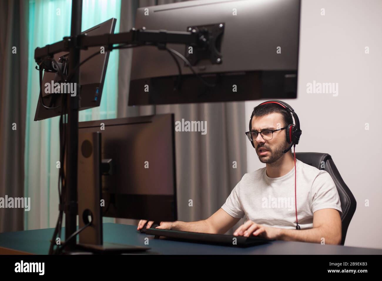 Man talking with others players using headphones with microphone while ...