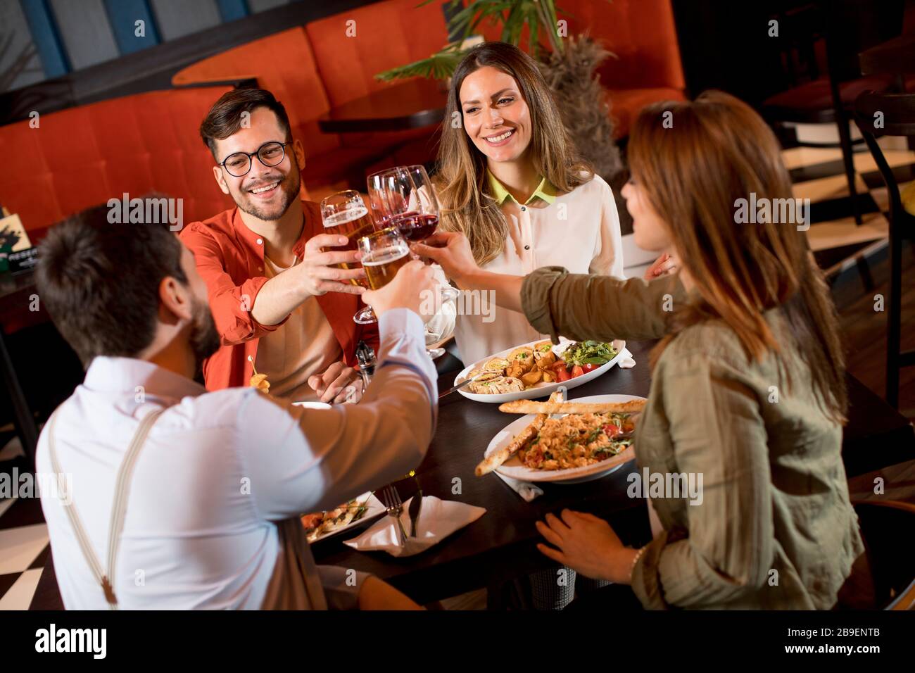 Group of young people having dinner in the restaurant Stock Photo - Alamy
