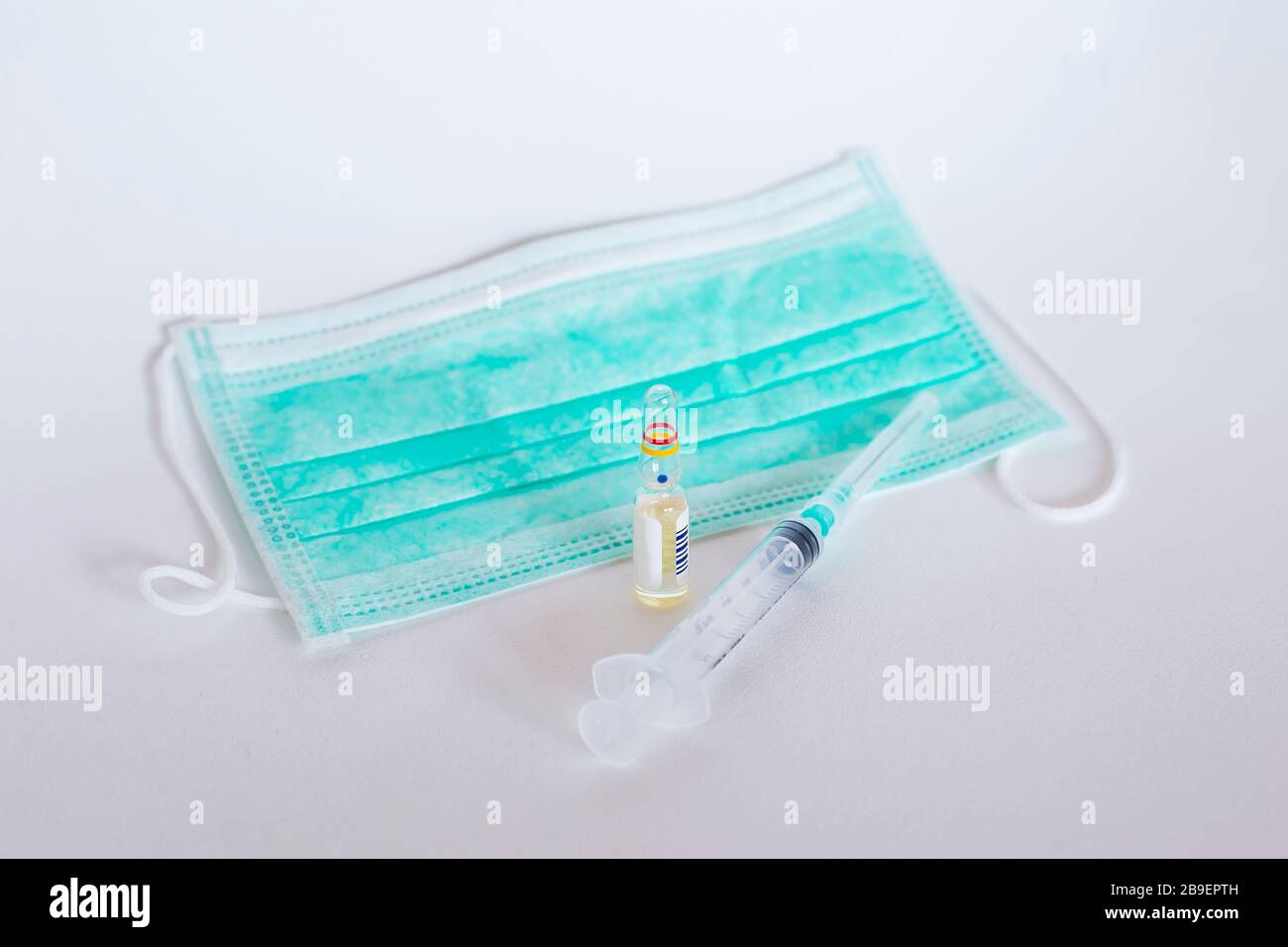 Surgical ear-loop mask and injection syringe on the table Stock Photo ...