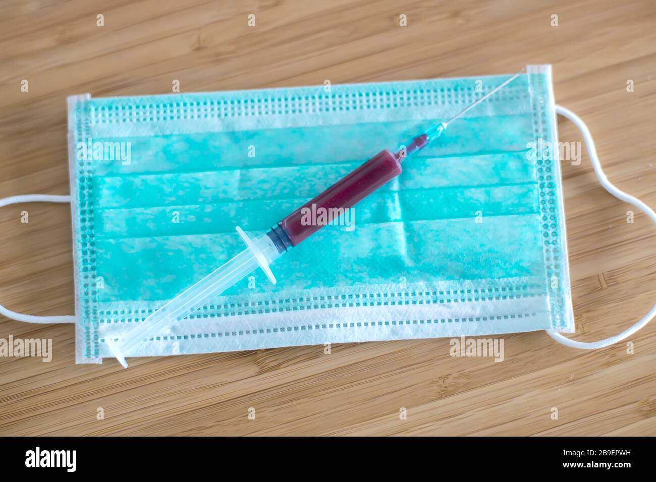 Surgical ear-loop mask and injection syringe on the table Stock Photo ...
