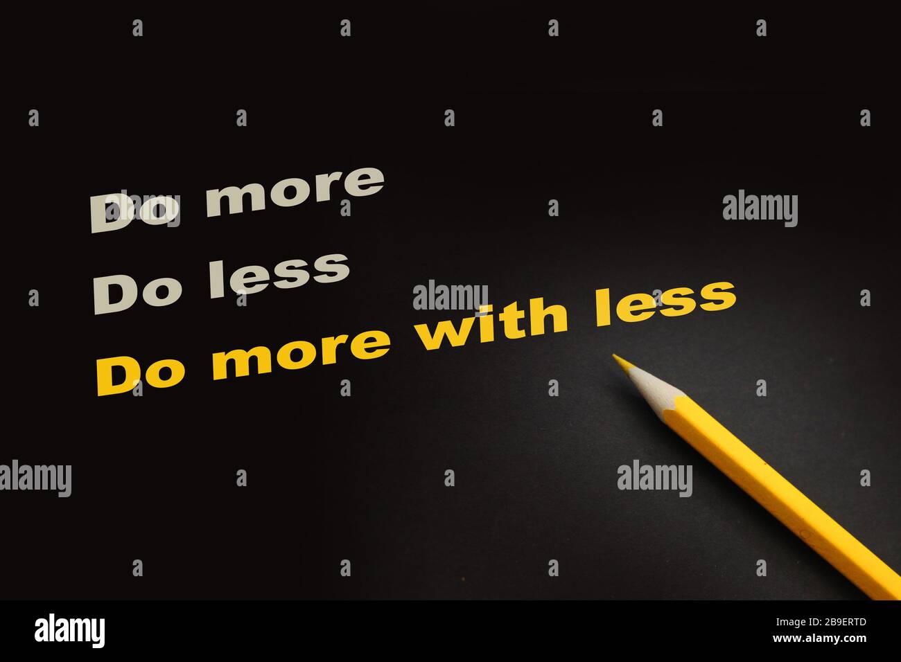 Do More With Less with yellow pencil on textured black paper. Lifestyle ...
