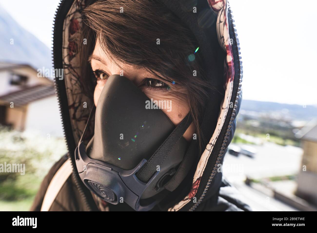 woman with a gas mask walking on the city streets surviving a corona ...