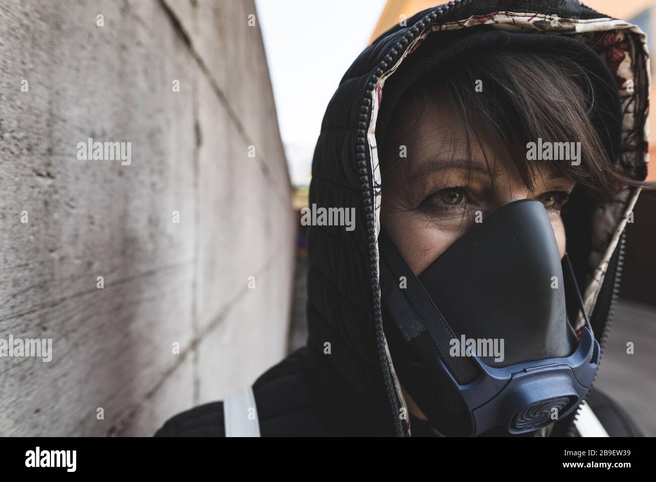 woman with a gas mask walking on the city streets surviving a corona ...