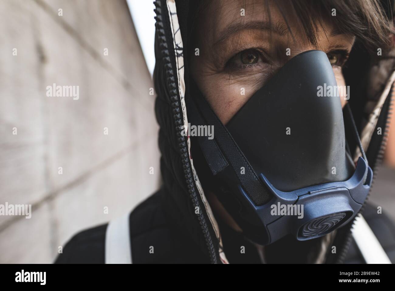 woman with a gas mask walking on the city streets surviving a corona ...