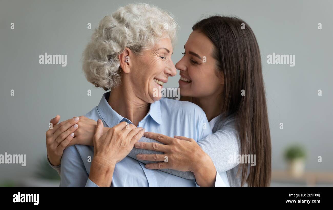 Smiling adult daughter and senior mother hug at home Stock Photo - Alamy