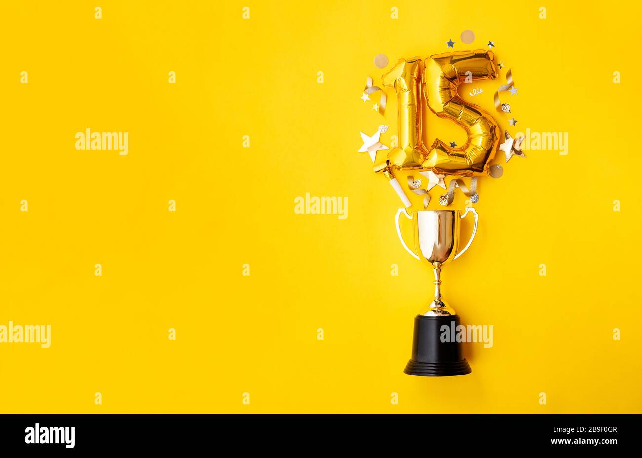 Number 15 gold anniversary celebration balloon exploding from a winning ...