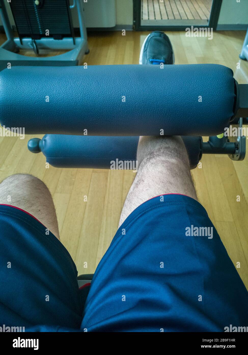 Doing Exercises at Gym: Leg Extensions Workout on Fitness Machine ...