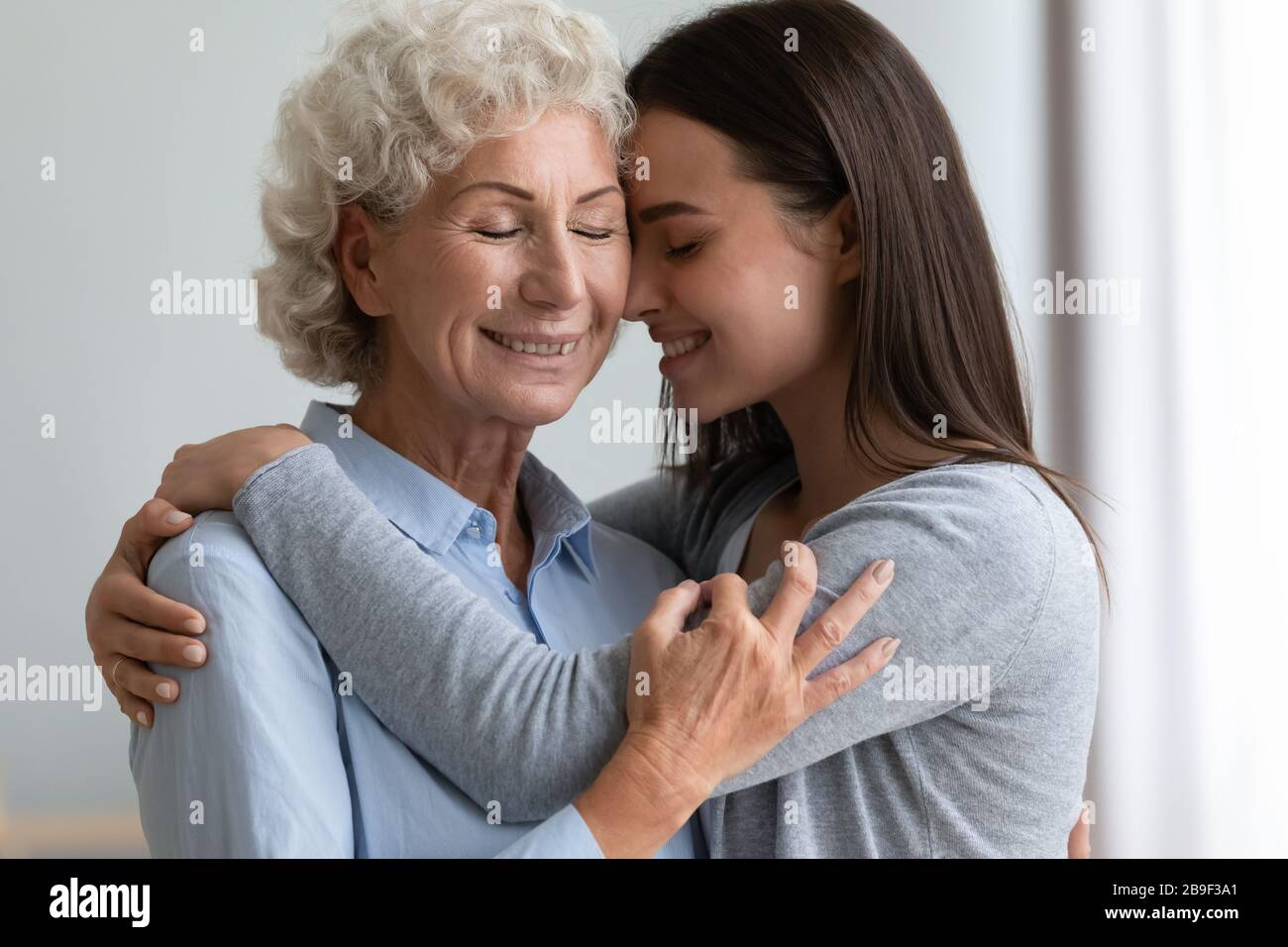 Loving elderly mom and adult daughter hugging Stock Photo - Alamy