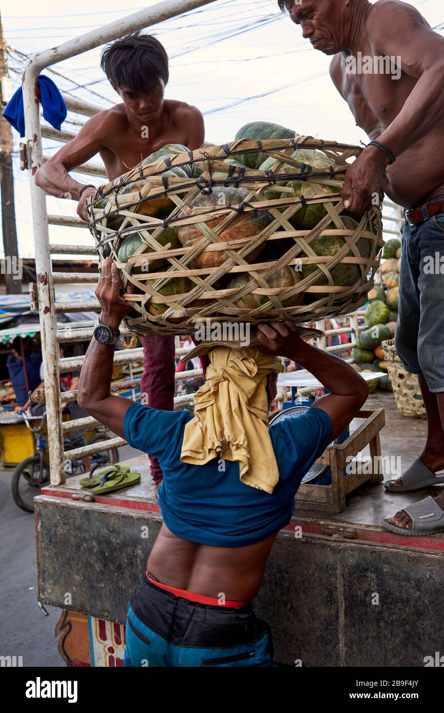 Porter carrying a heavy load in the streets of the Carbon public market ...