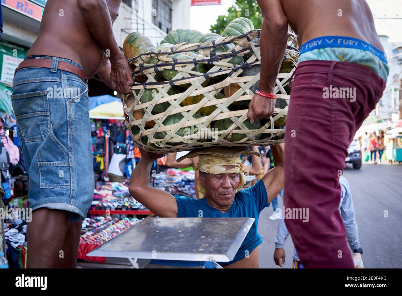 Porter carrying a heavy load in the streets of the Carbon public market ...